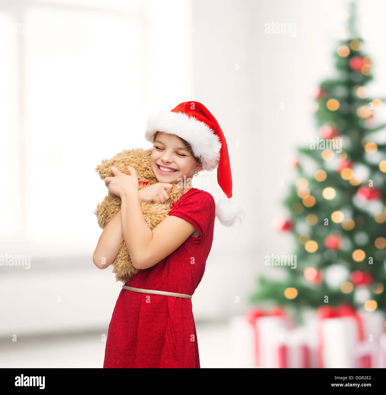 smiling girl in santa helper hat with teddy bear Stock Photo - Alamy
