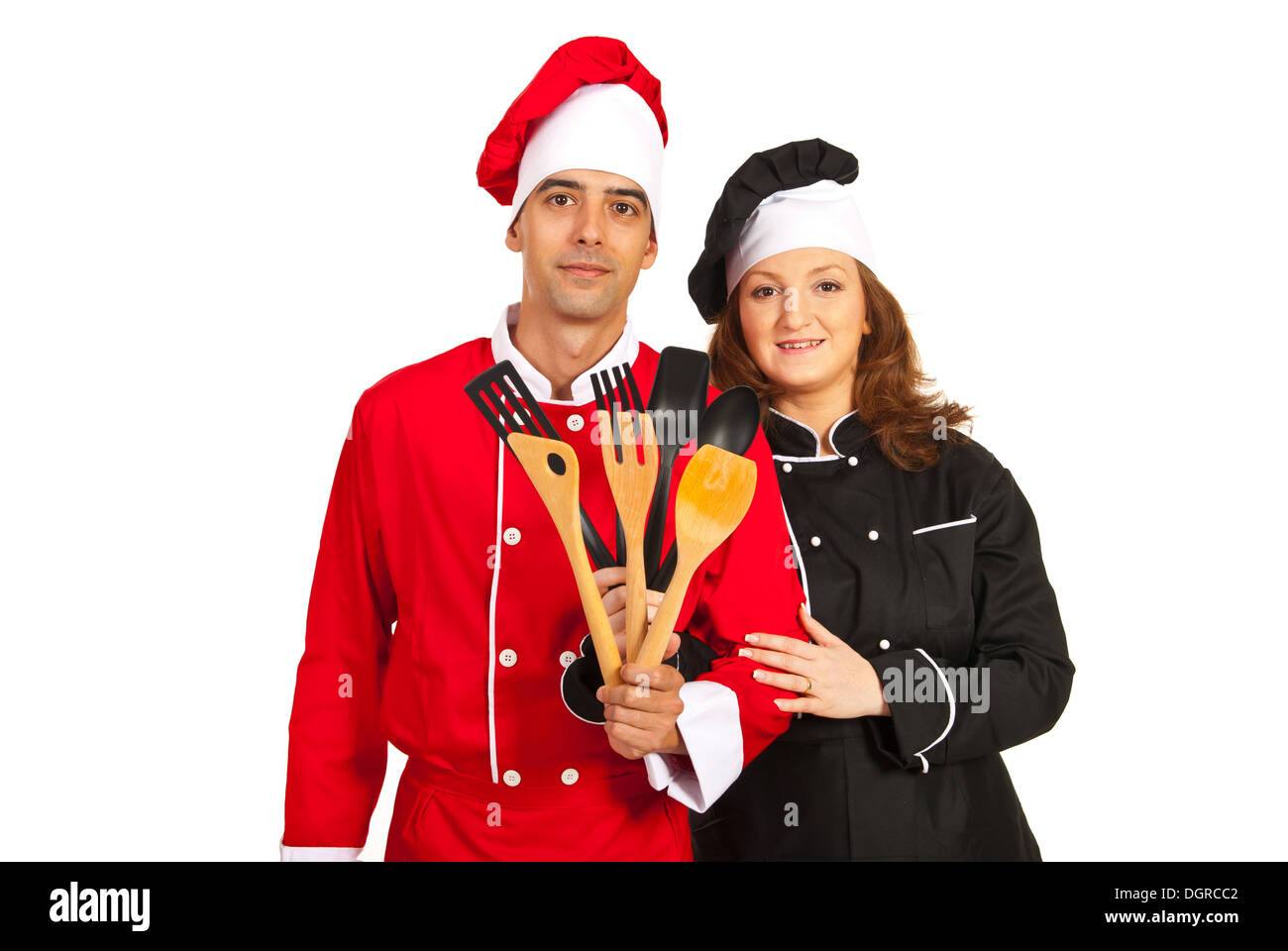 Cheerful couple of chefs showing kitchen utensils isolated on white ...