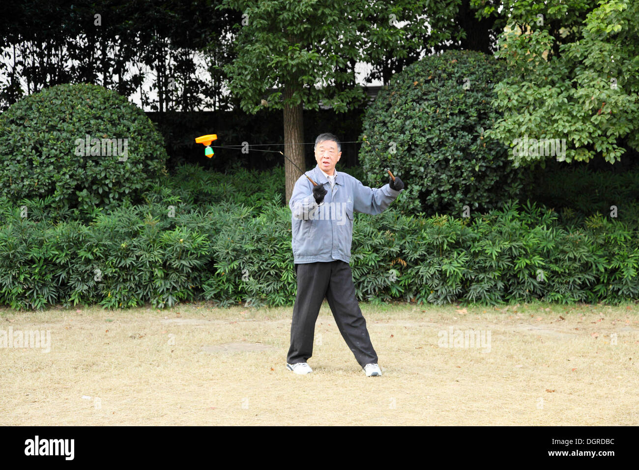 Chinese man playing Yo Yo game in a park. Shanghai, China Stock Photo ...