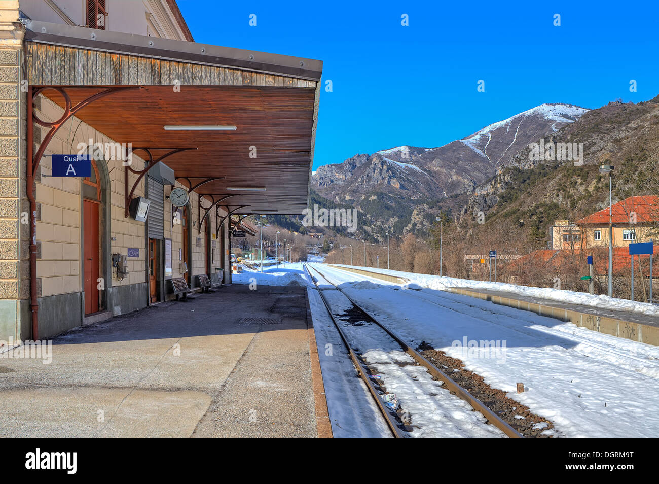 Rails covered with snow along empty platform on small railway station ...