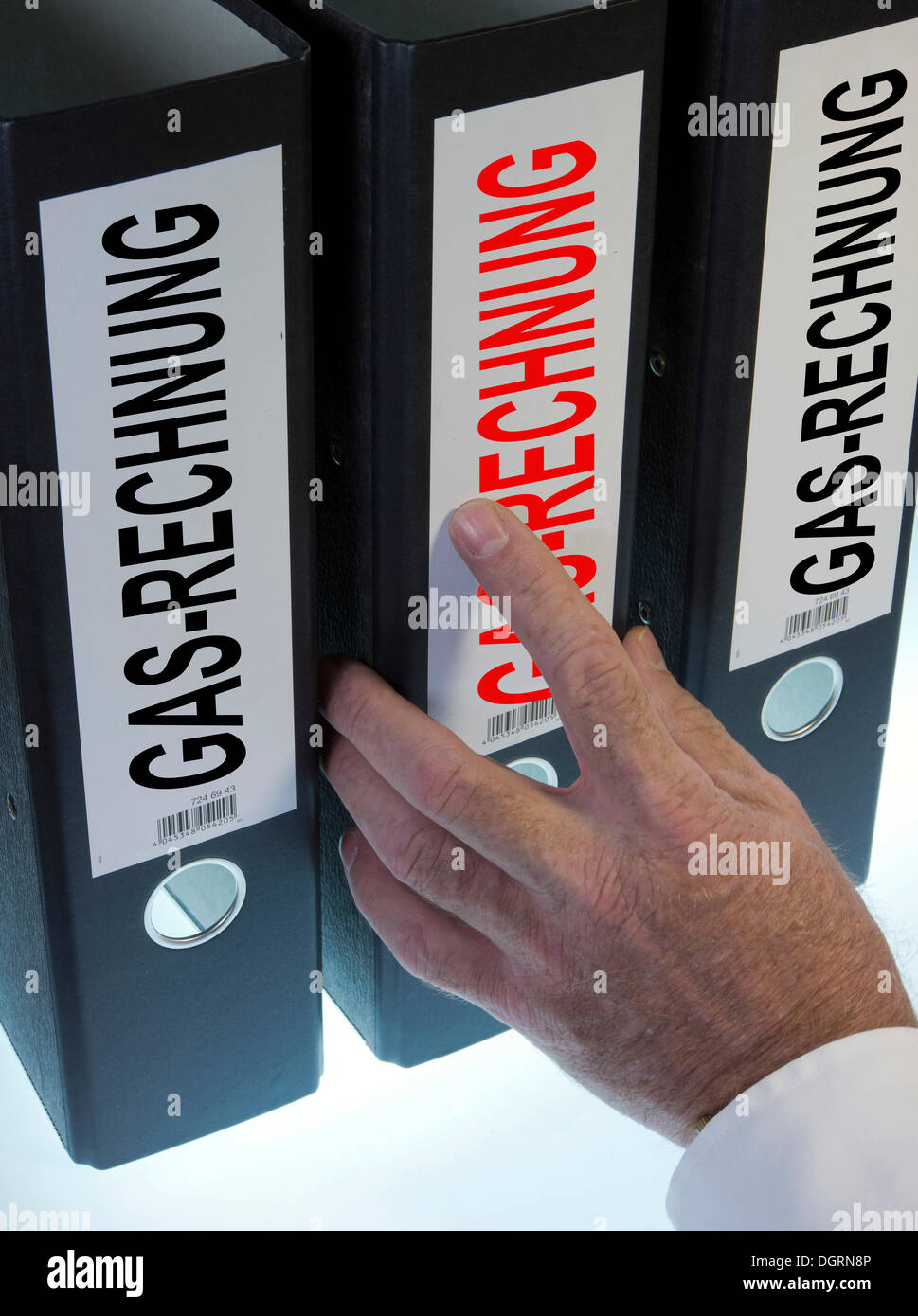 Hand reaching for a ring binder labeled Gasrechnung, German for gas ...
