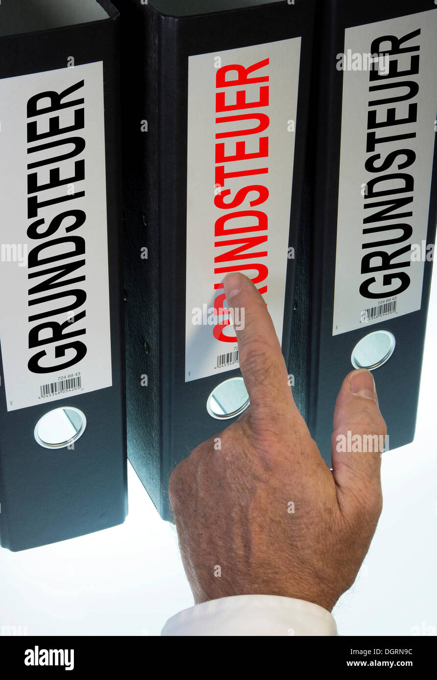 Hand pointing to file folders labeled "Grundsteuer", German for "land ...