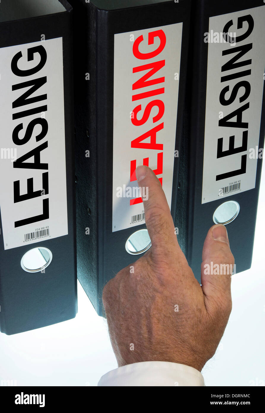 Hand pointing to a ring binder labelled "LEASING Stock Photo - Alamy