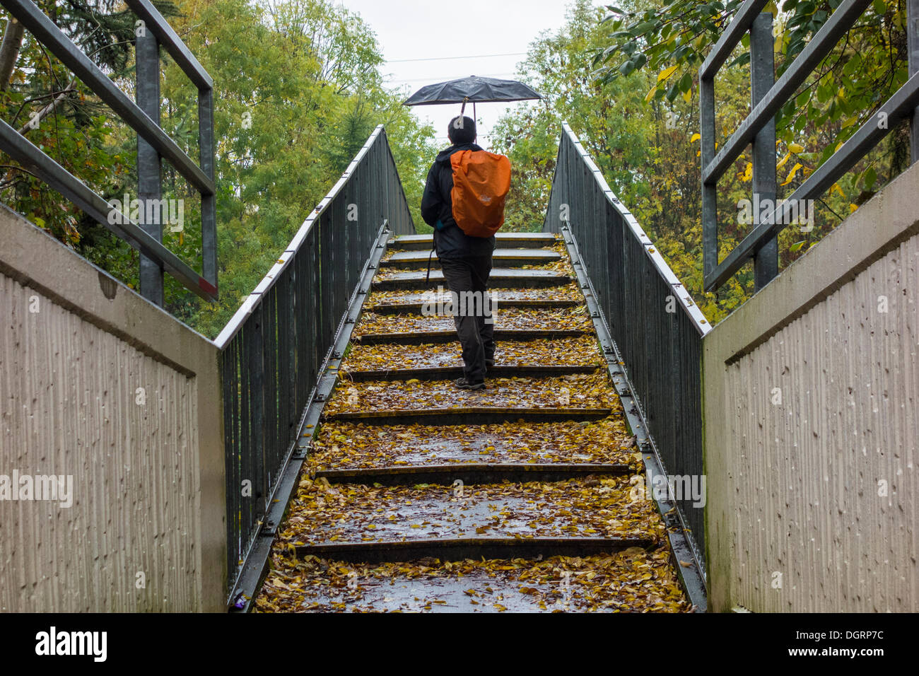 Billingham, UK. 25th Oct, 2013. Man with umbrella crossing road bridge ...