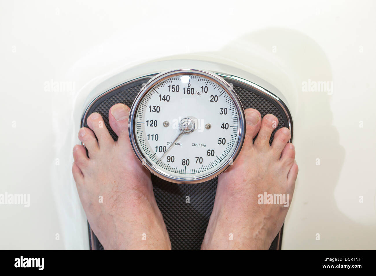 A man standing on bathroom scales Stock Photo - Alamy