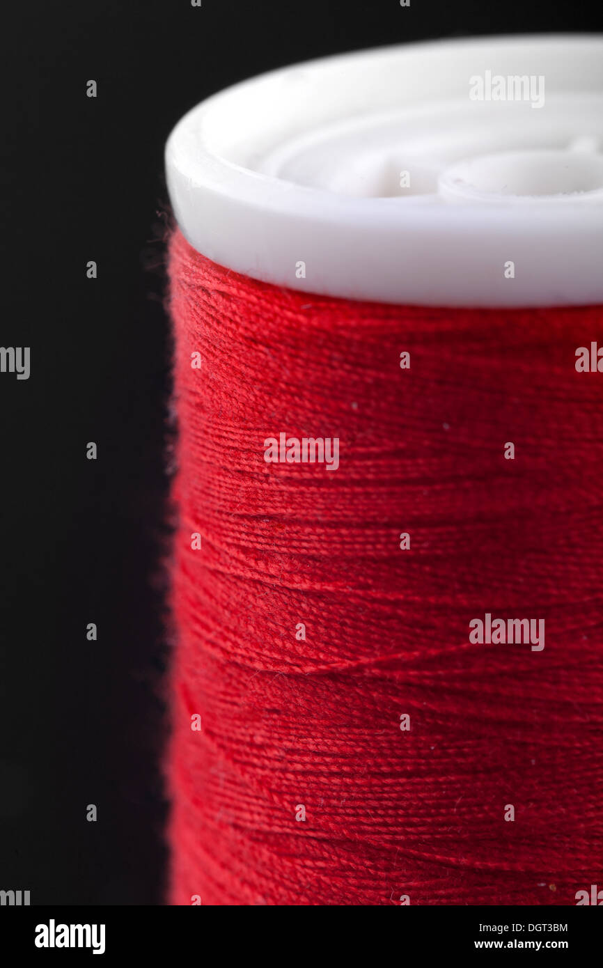 macro shot of red bobbin thread isoladed on black background Stock ...