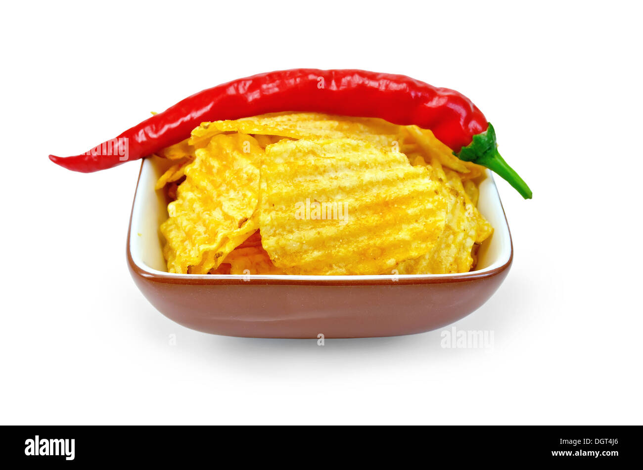 Corrugated potato chips in a clay bowl with fresh red chili peppers ...