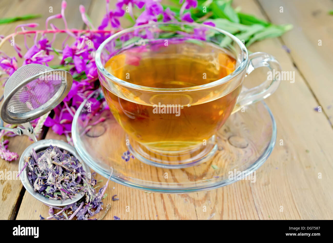 Herbal tea in a glass cup, a strainer with dry flowers fireweed, fresh ...