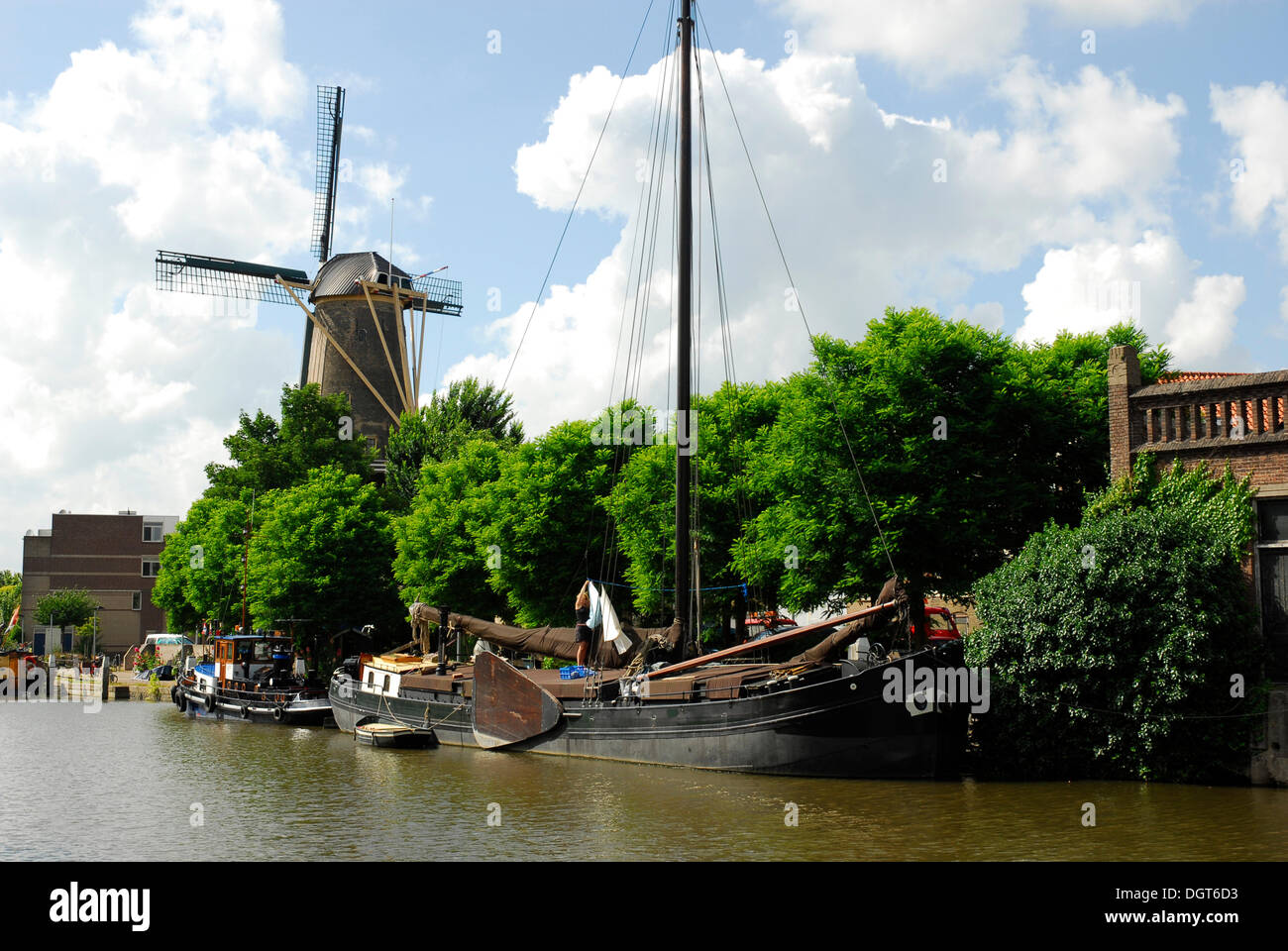 Windmill and traditional sailing ship in the harbor, Binnenhaven, Gouda ...
