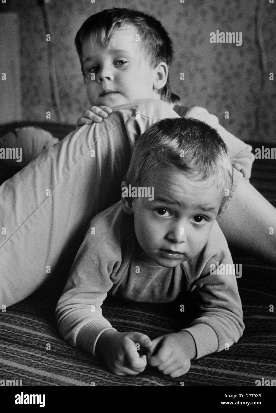 Children playing at their mother's leg, East Germany, German Democratic ...