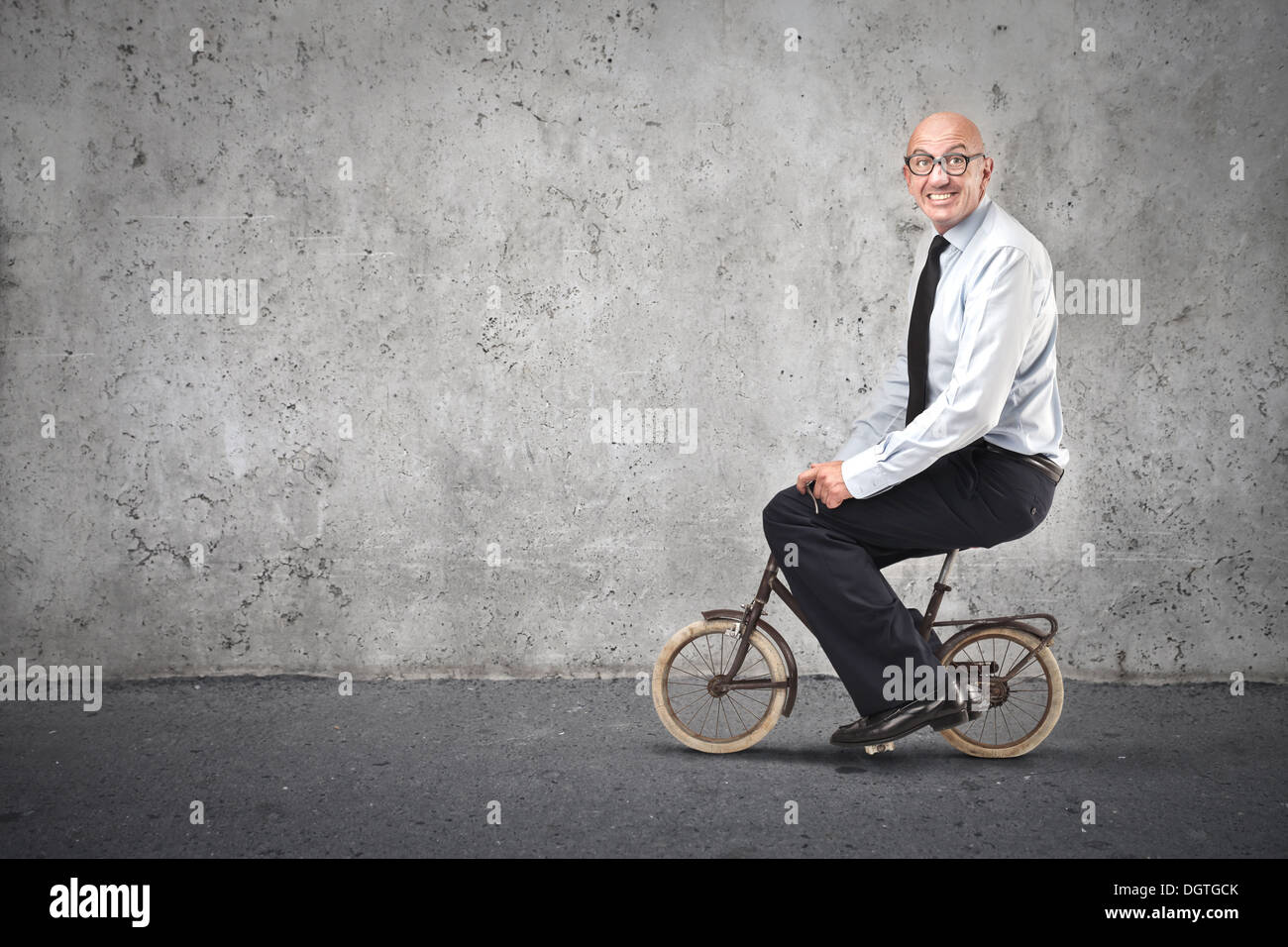 Bald man cycling on a little bike Stock Photo - Alamy