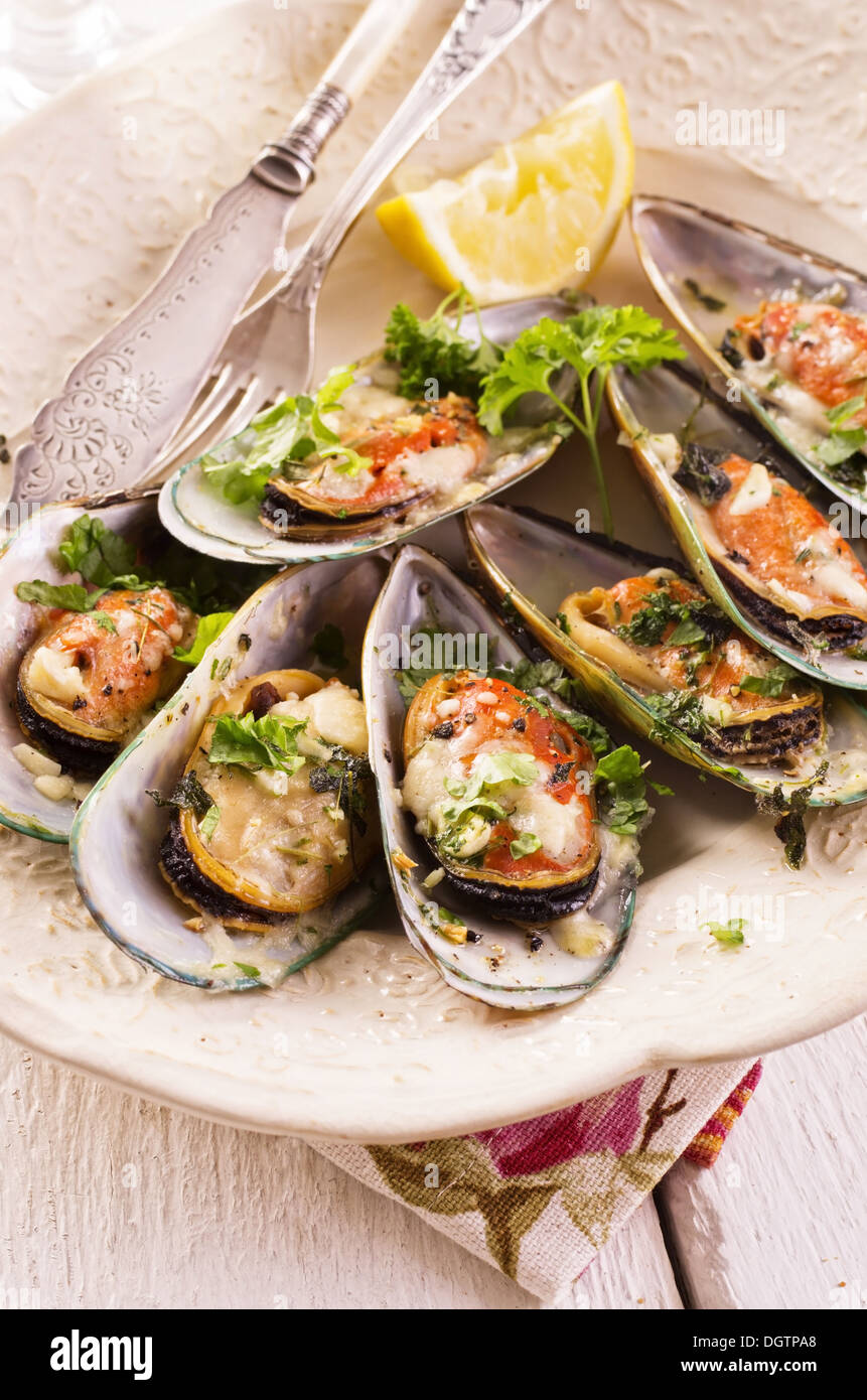 mussels baked with cheese and herbs Stock Photo - Alamy