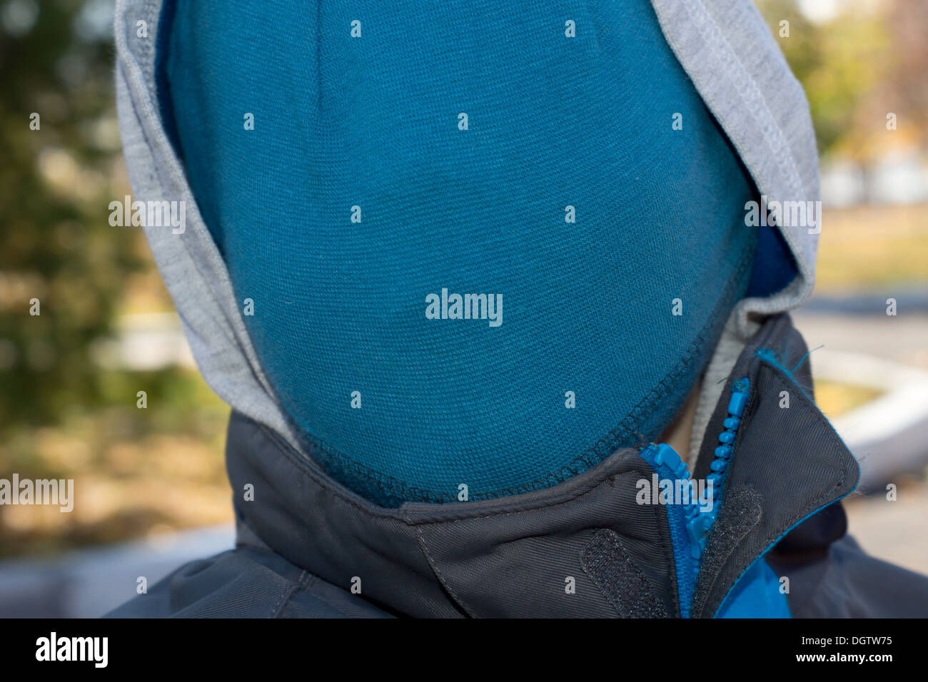Person with a hidden face concealed under a blue knitted fabric and ...