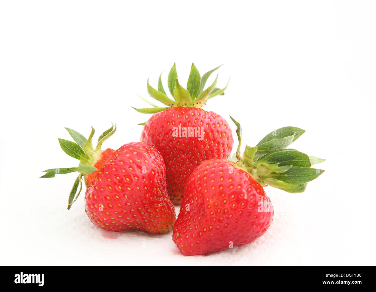 Three strawberries on a white background Stock Photo - Alamy
