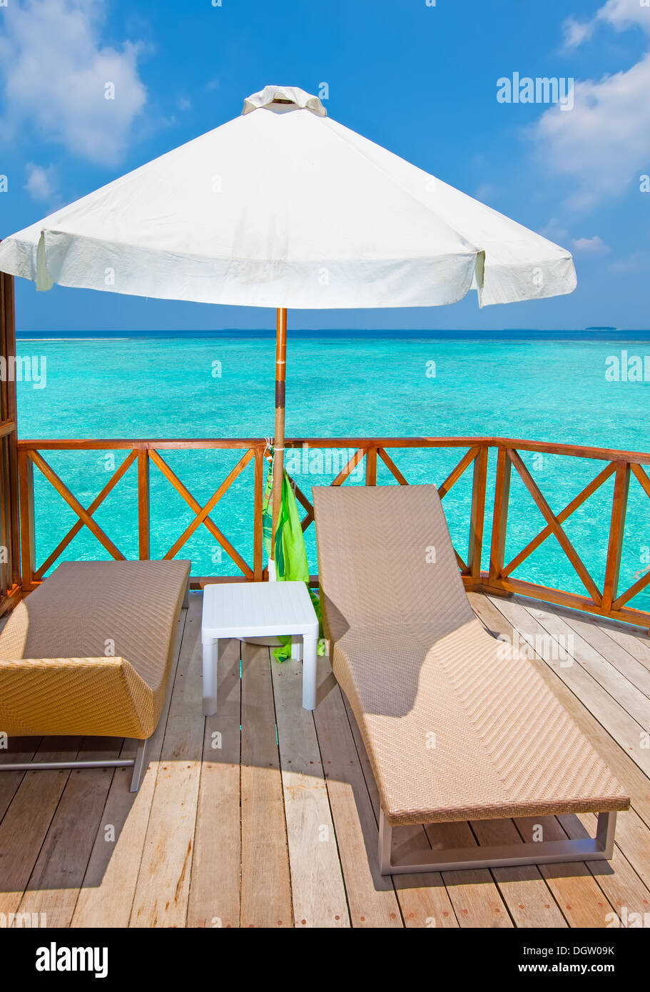 Parasol and chaise lounges on a terrace Stock Photo - Alamy