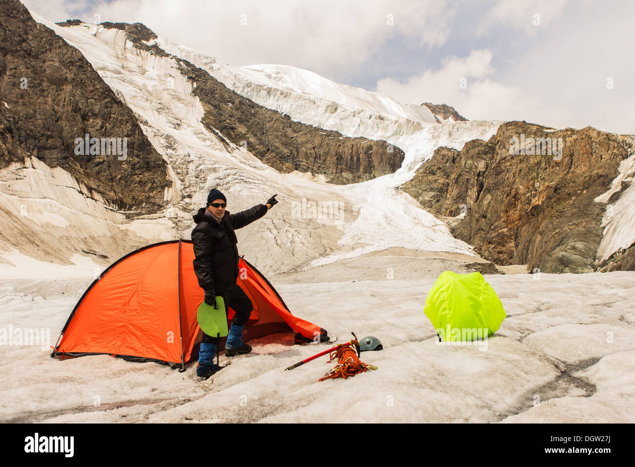 The climber standing near tent on glacier Stock Photo - Alamy