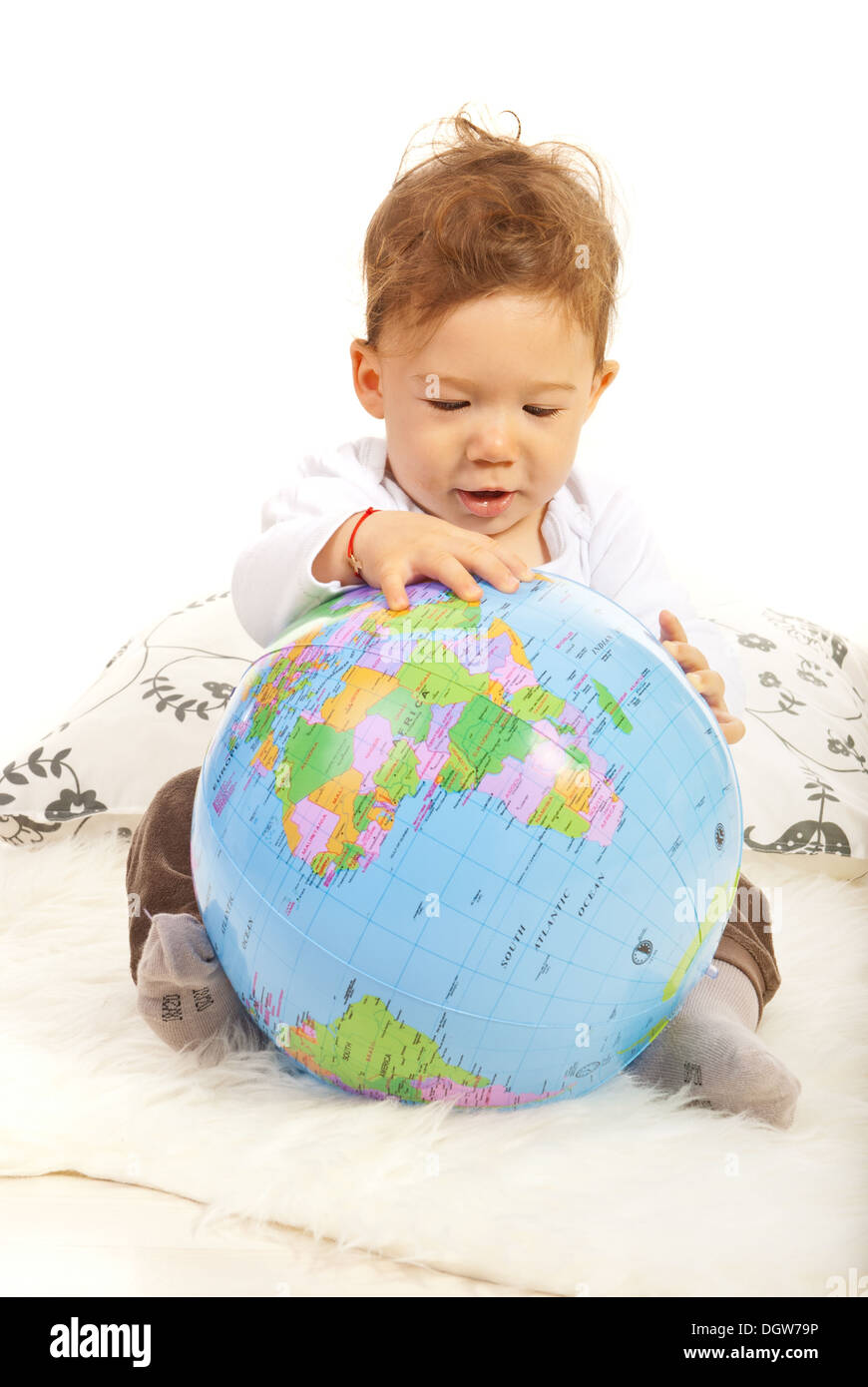 Baby boy sitting down and searching world globe Stock Photo - Alamy