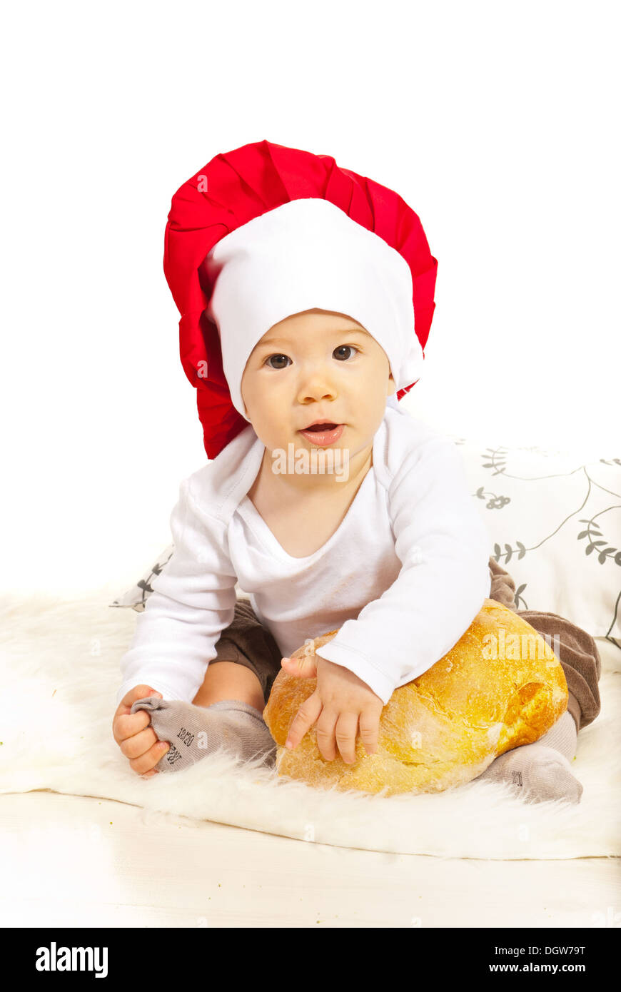 Beauty chef baby with bread sitting down on fur blanket Stock Photo - Alamy