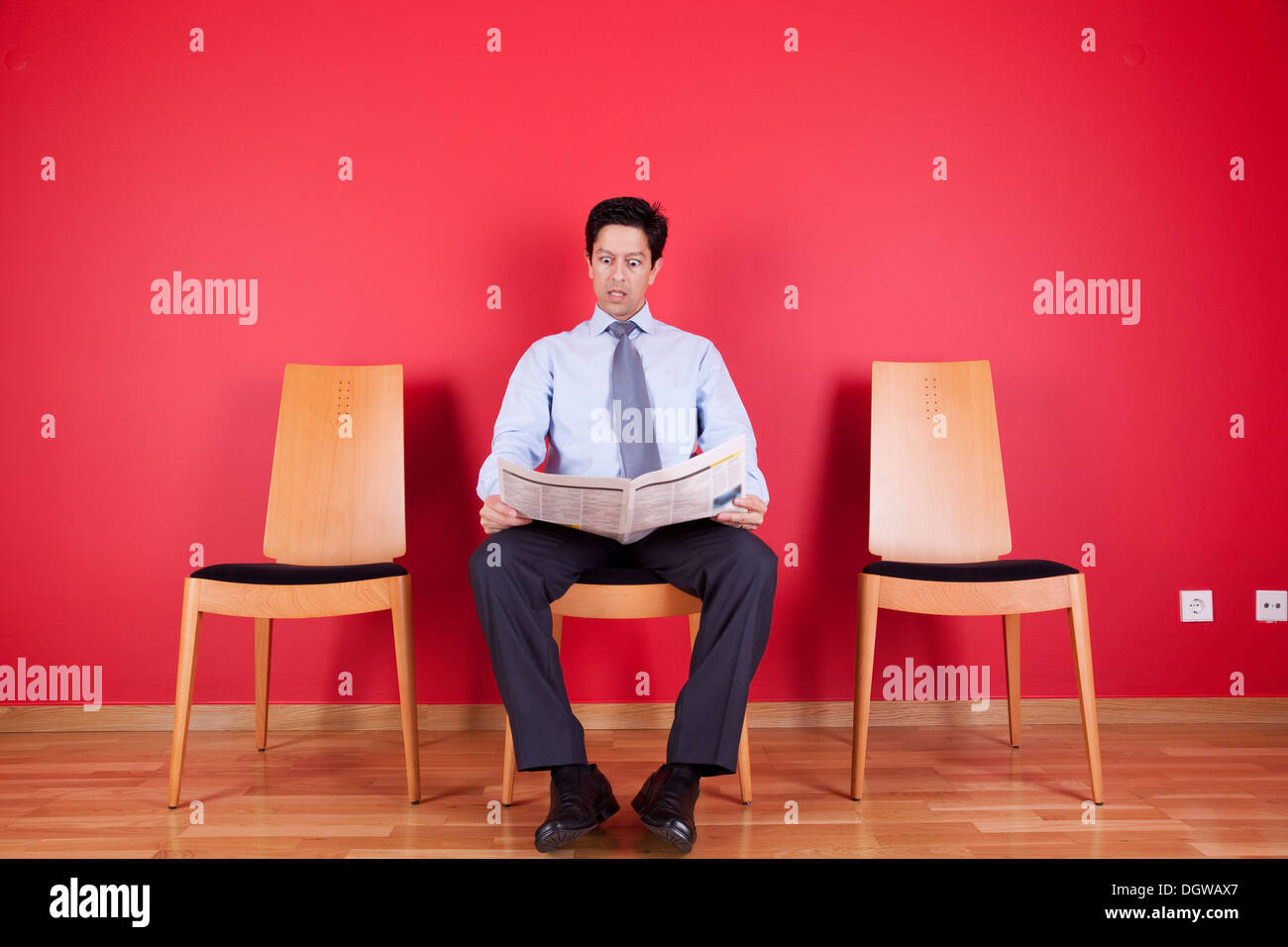 businessman reading the newspaper siting on a chair Stock Photo - Alamy
