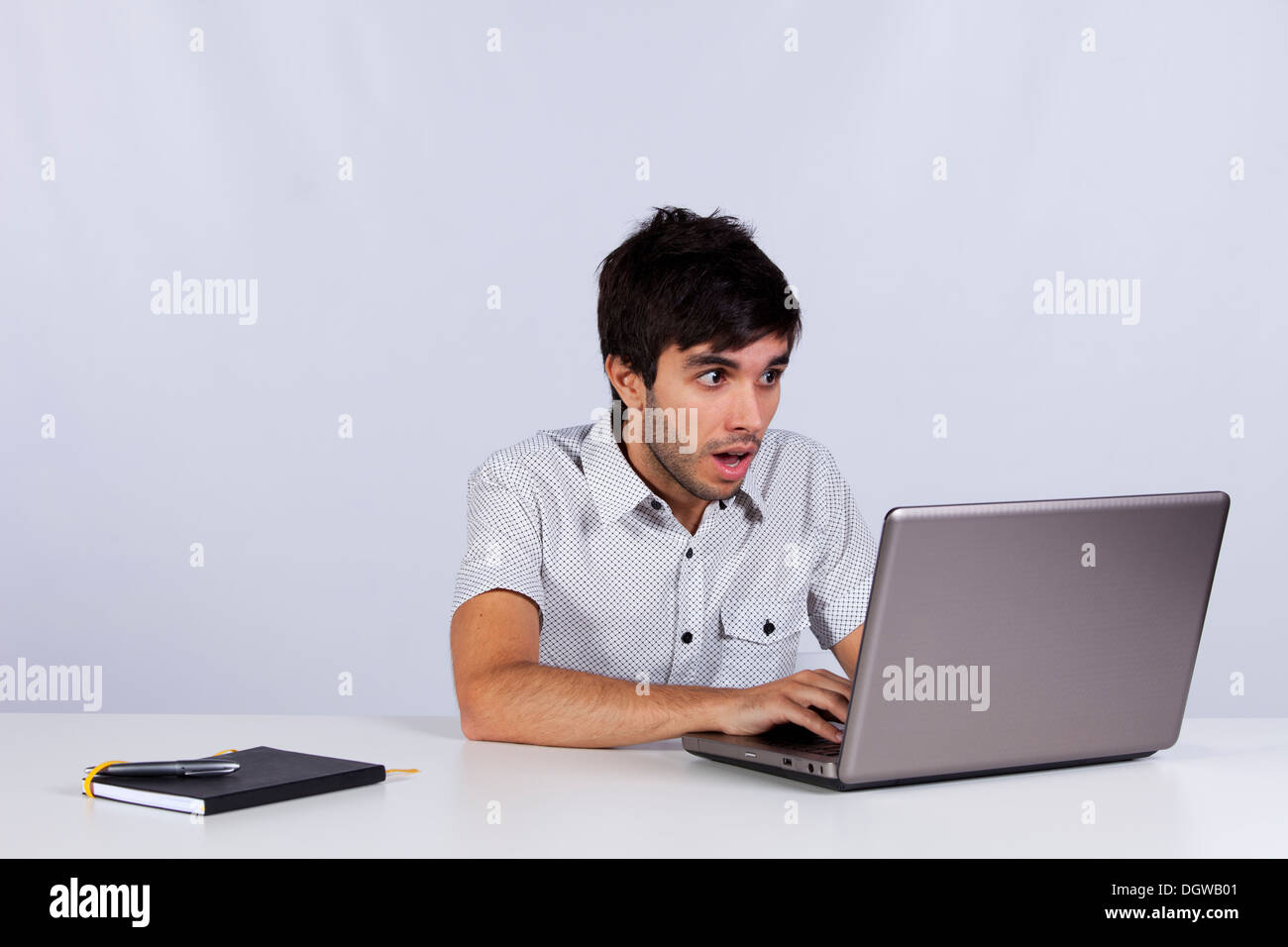 young man shocked with something he see on his laptop computer Stock ...
