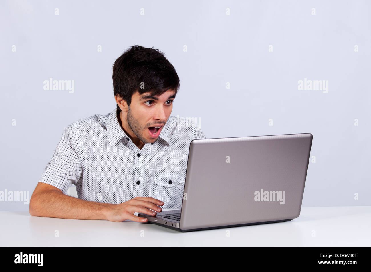 young man shocked with something he see on his laptop computer Stock ...