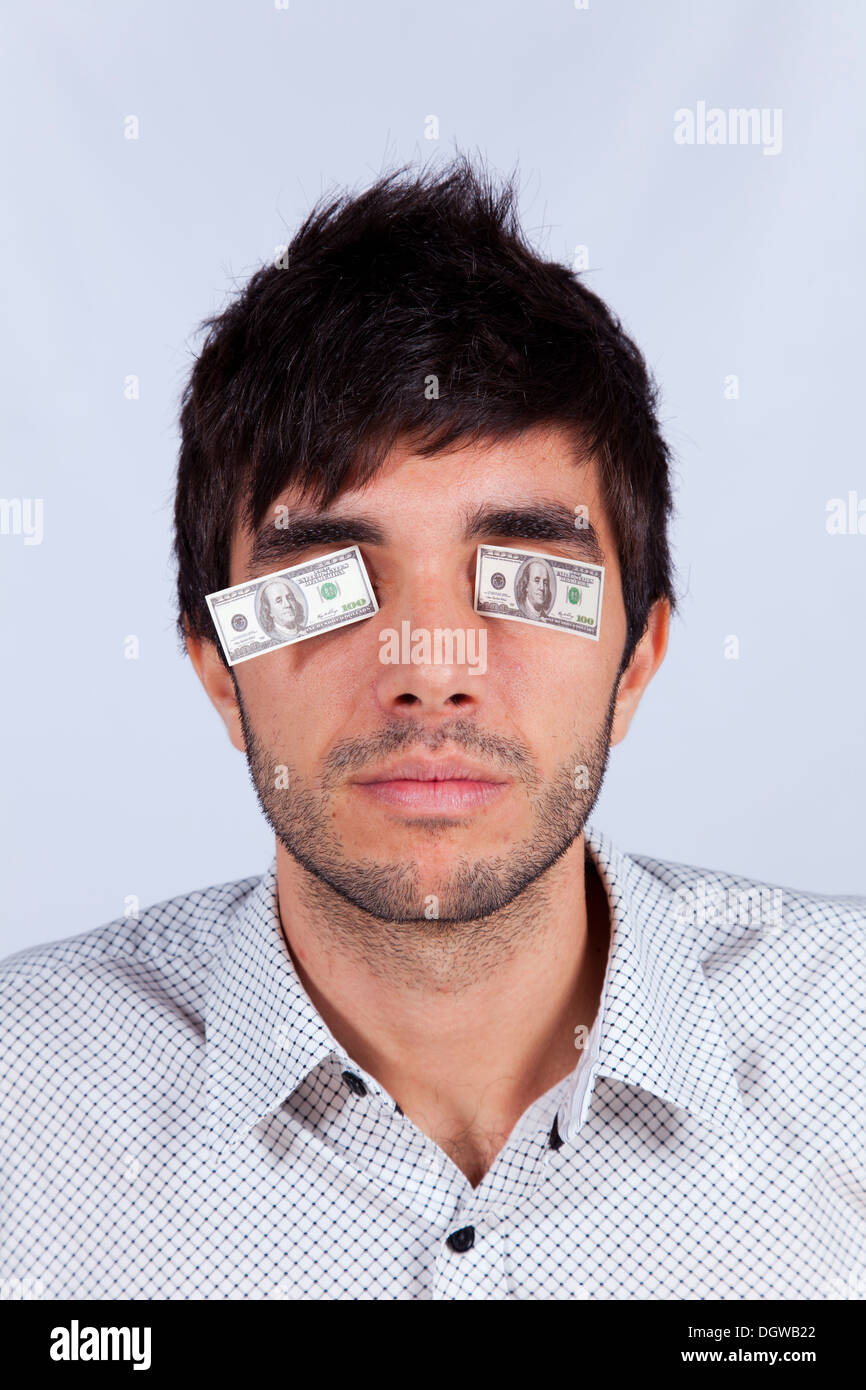 Young man with little dollar bills covering his eyes Stock Photo - Alamy