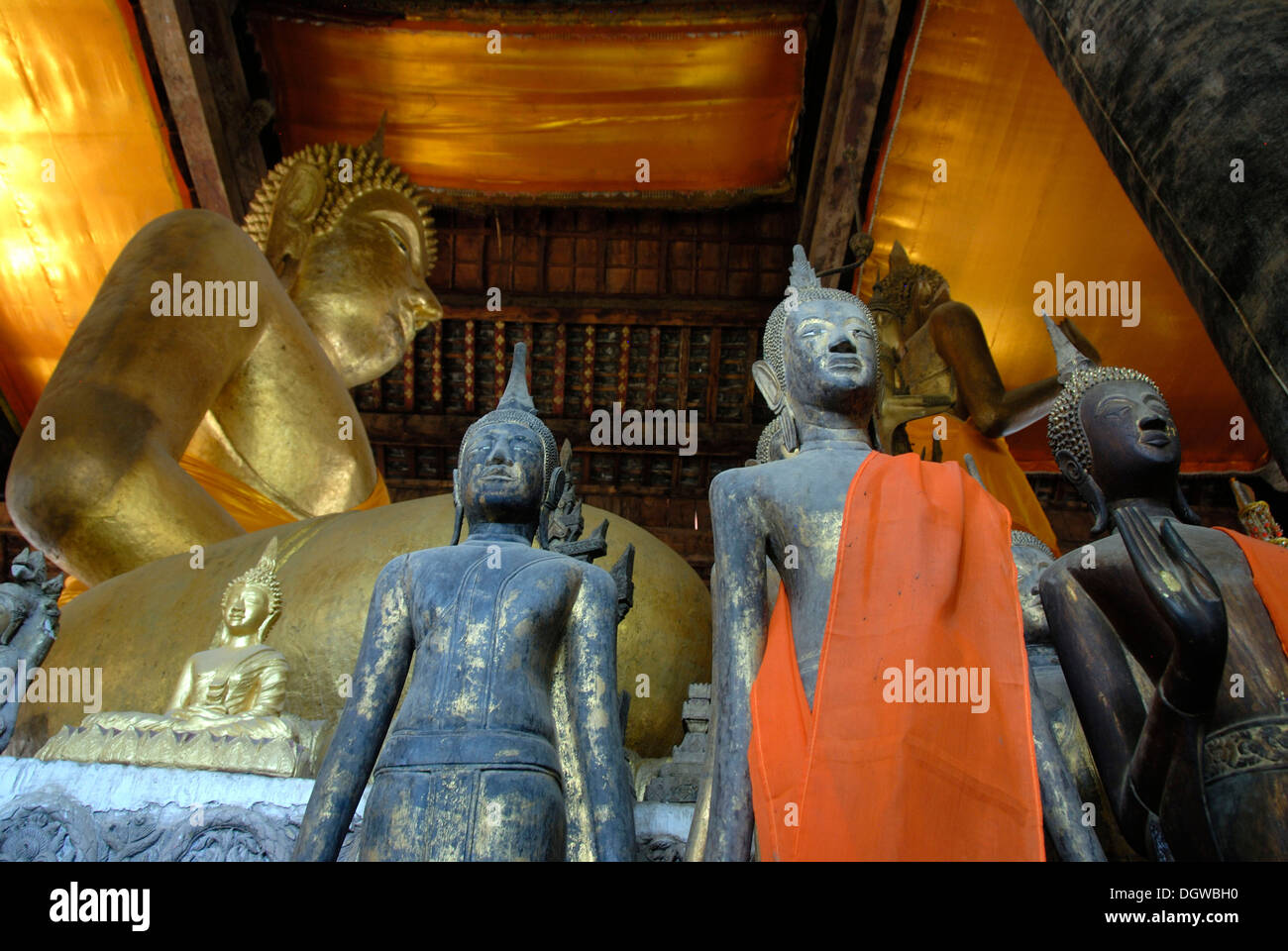 Theravada Buddhism, large Buddha statue in gold, small standing Buddha ...