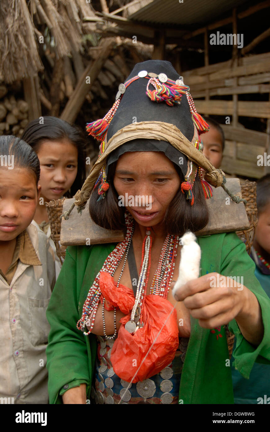 Portrait of a young woman of the Akha Eupa ethnic group concentrating ...