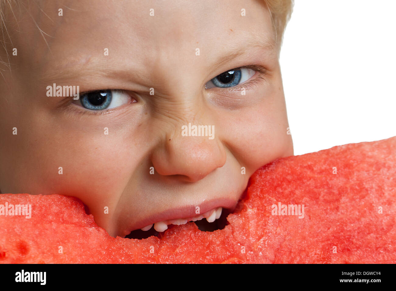 A close-up shot of boy taking big bite a big juicy slice of watermelon ...