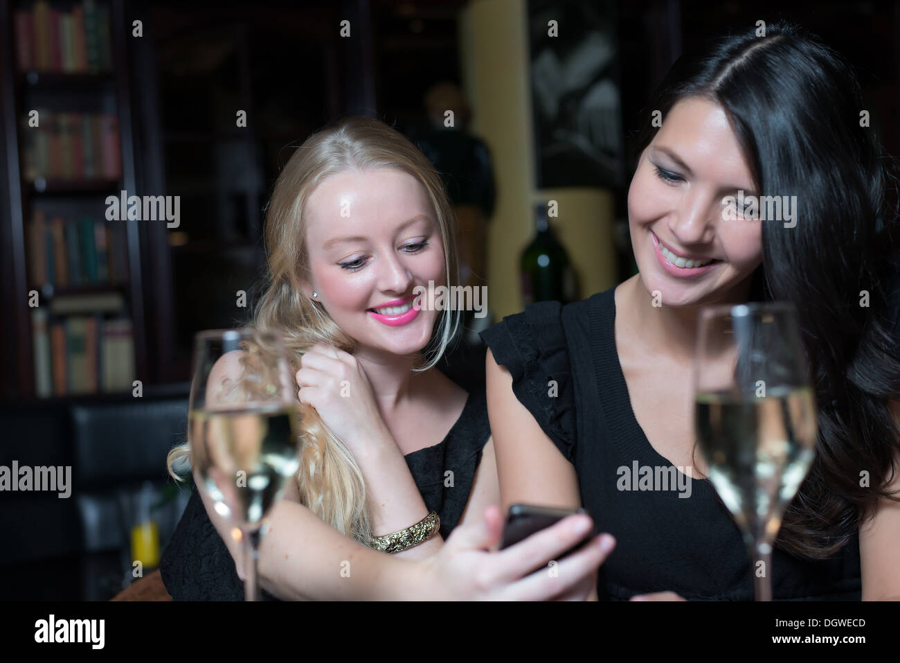 Two beautiful women friends looking at their smart phone Stock Photo ...