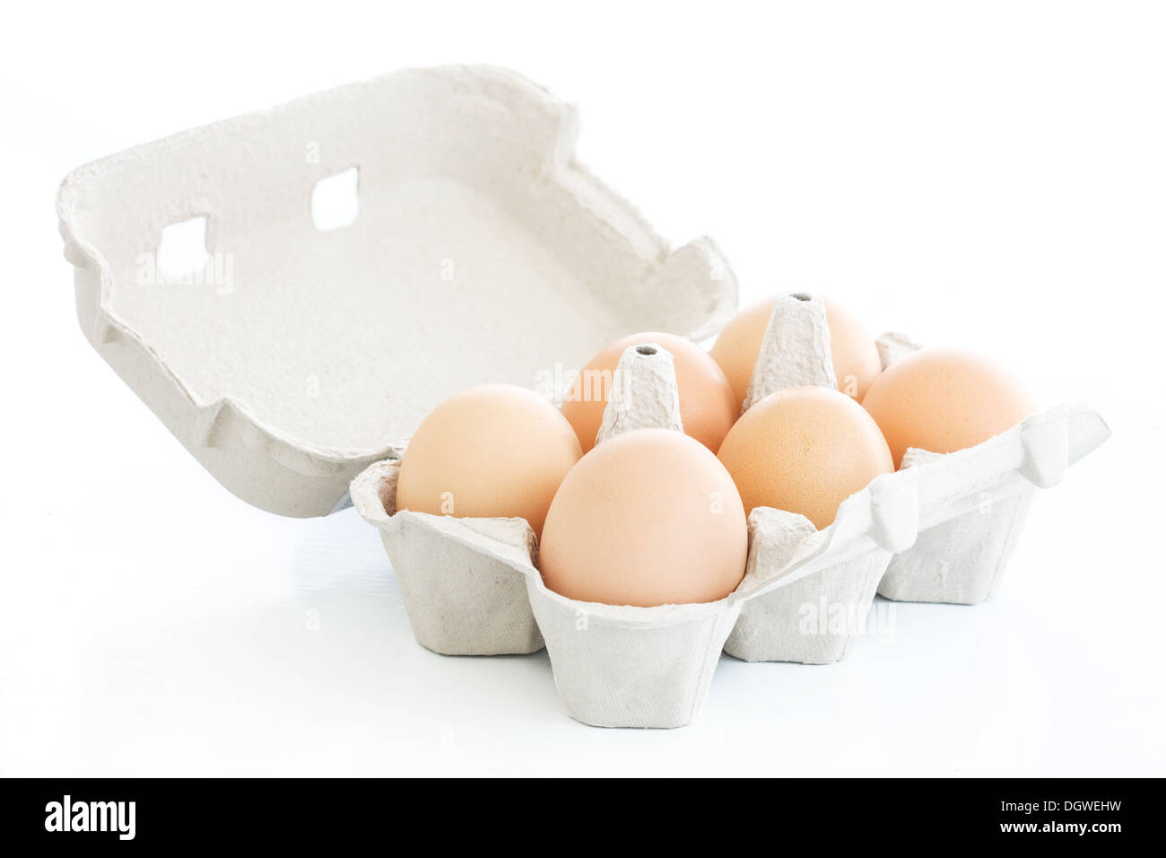 Six eggs on a carton box over a white background Stock Photo - Alamy