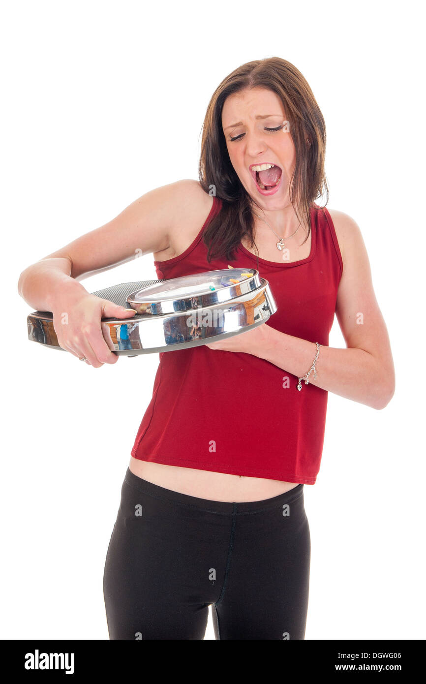 an angry girl with a weighing scale, on a white background Stock Photo ...