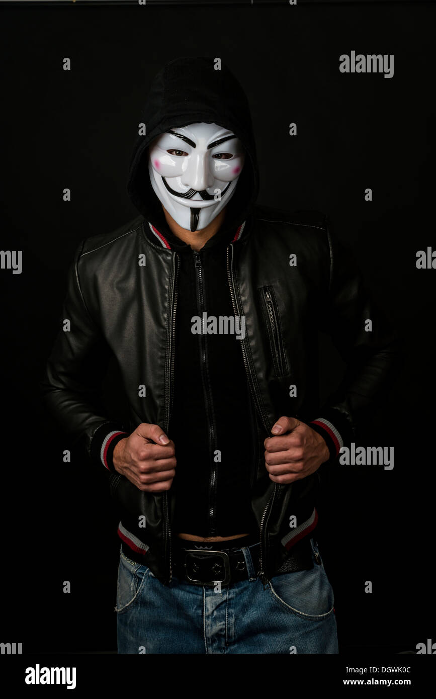 Young man wearing an anonymous mask with a hood and a black leather ...