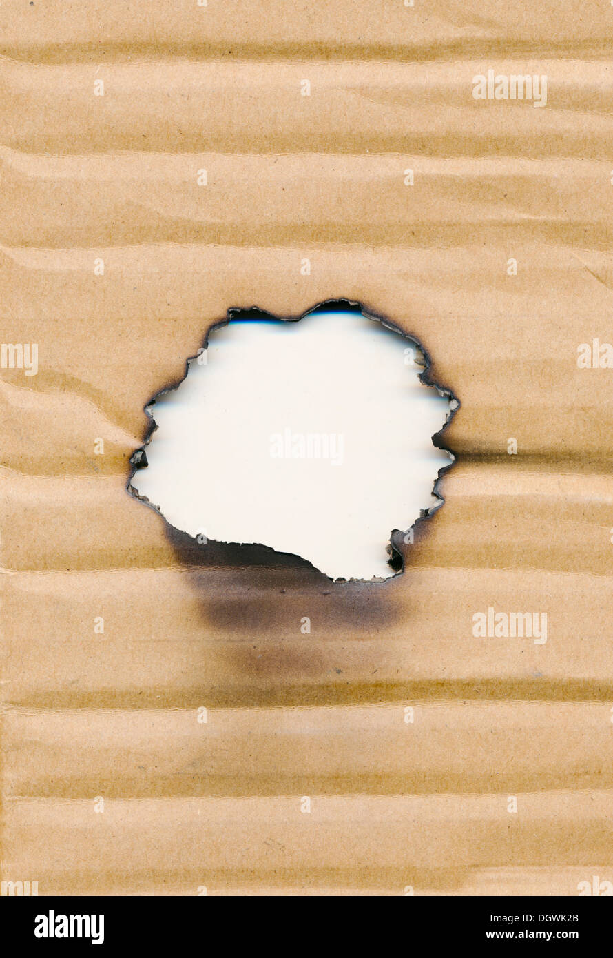 burn hole on corrugated paper Stock Photo - Alamy