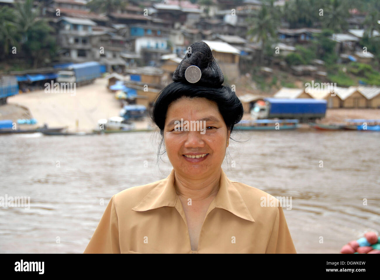 Portrait, smiling woman in the Tai Dam ethnic group, hair in a bun with ...