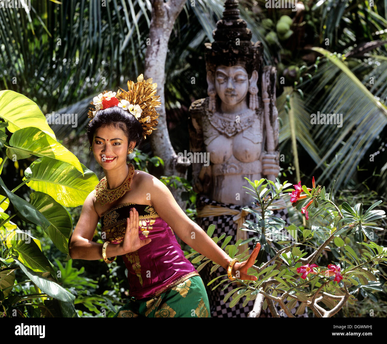 Balinese dancer wearing a traditional costume in front of a stone ...