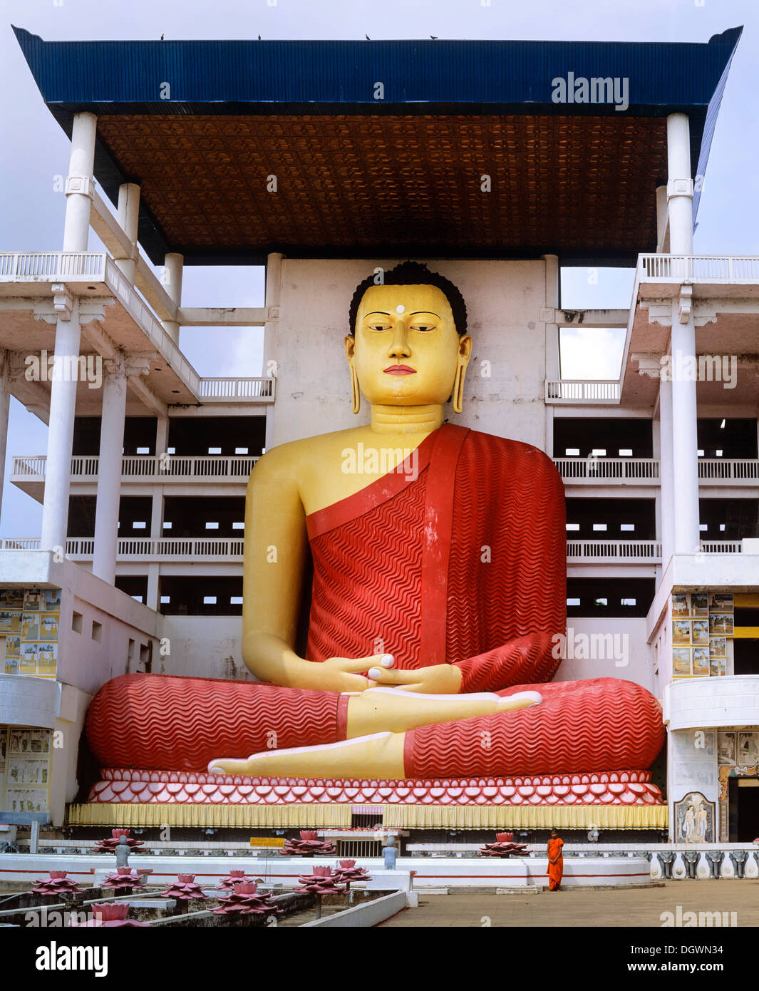 Giant Buddha statue at the Weherahena Temple, monk standing at front ...