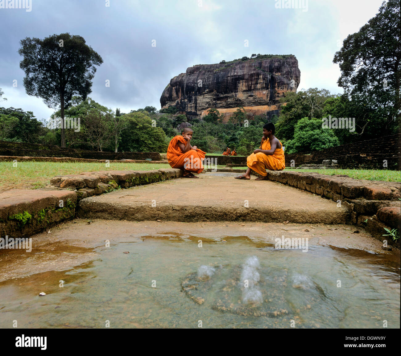 Monks sitting at the cistern, spring at the Rock of Sigiriya, Lion Rock ...
