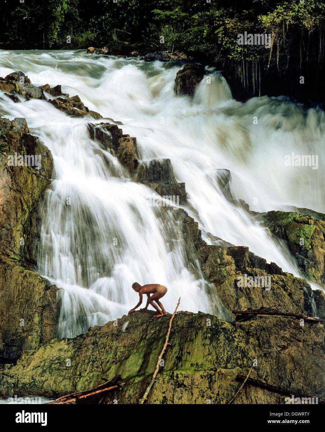 Man climbing on rocks at the Tad Somphamit waterfalls, waterfalls on ...