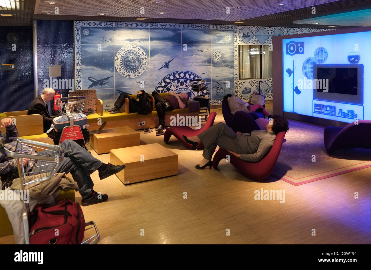 Passengers sleep and rest as they wait for their flight in a departure ...
