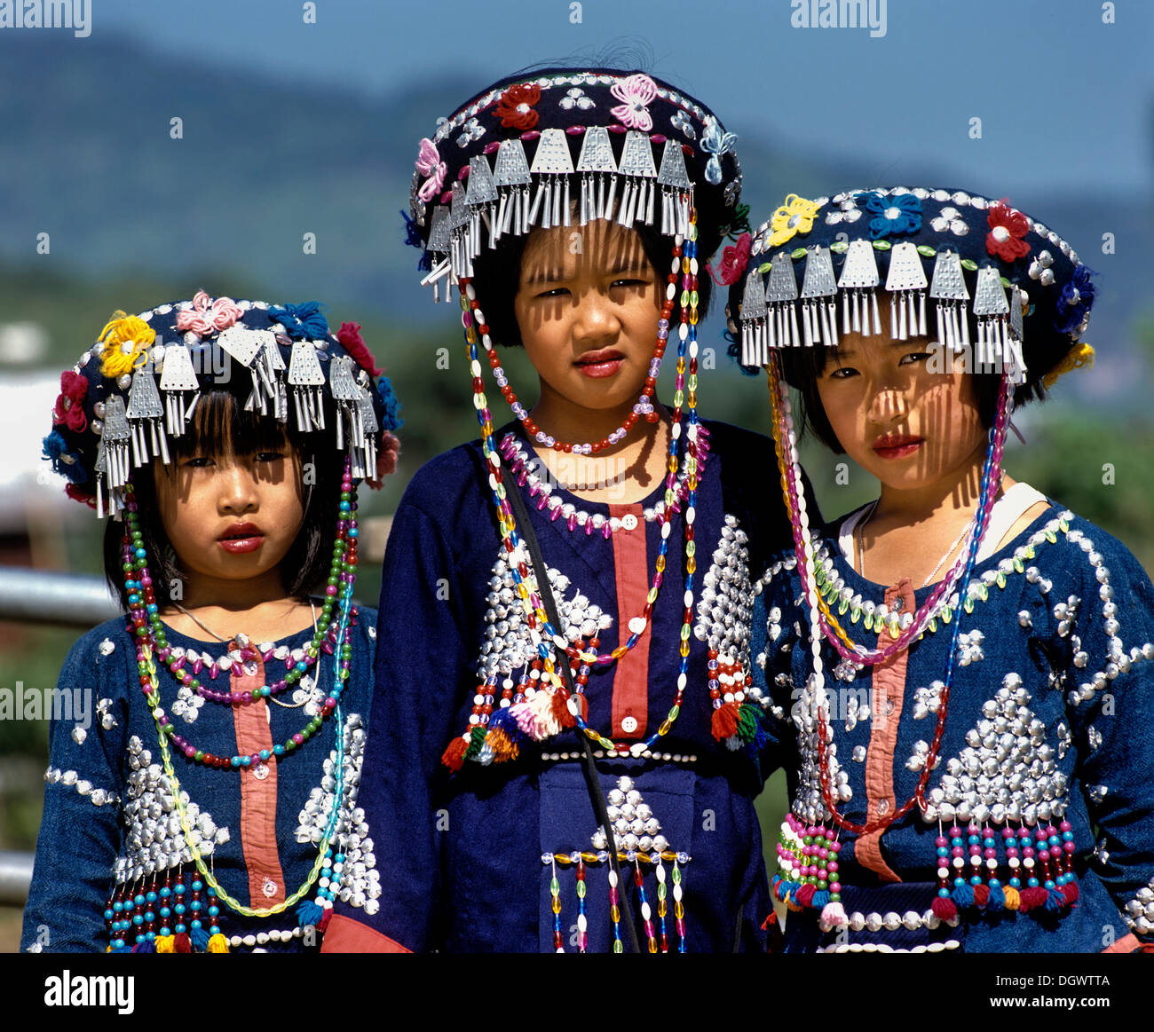 Three Lisu girls wearing colourful headdresses and the traditional ...