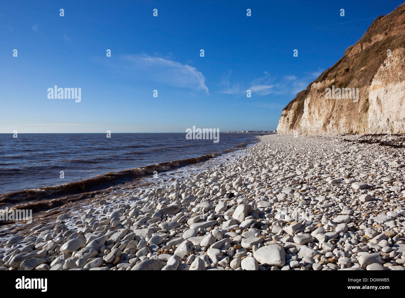 Rippled waves meeting white boulders and pebbles at the foot of chalk ...