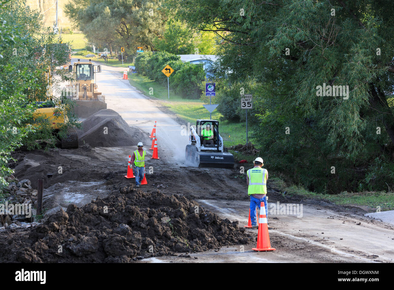 A work crew repairs a road damaged by flood water in Arvada, Colorado ...