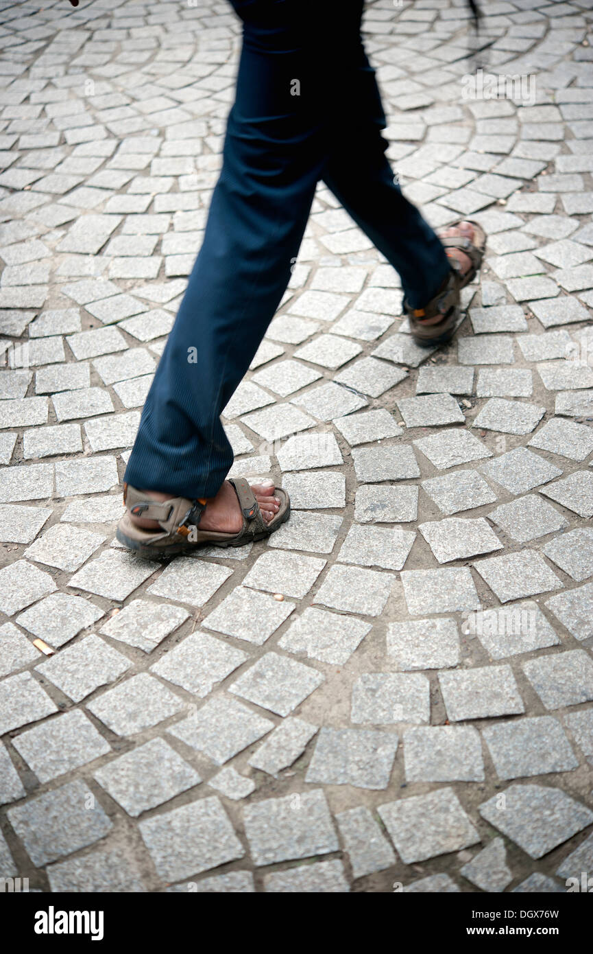 Movement of commuters feet walking across cobbled pavement - scene from ...