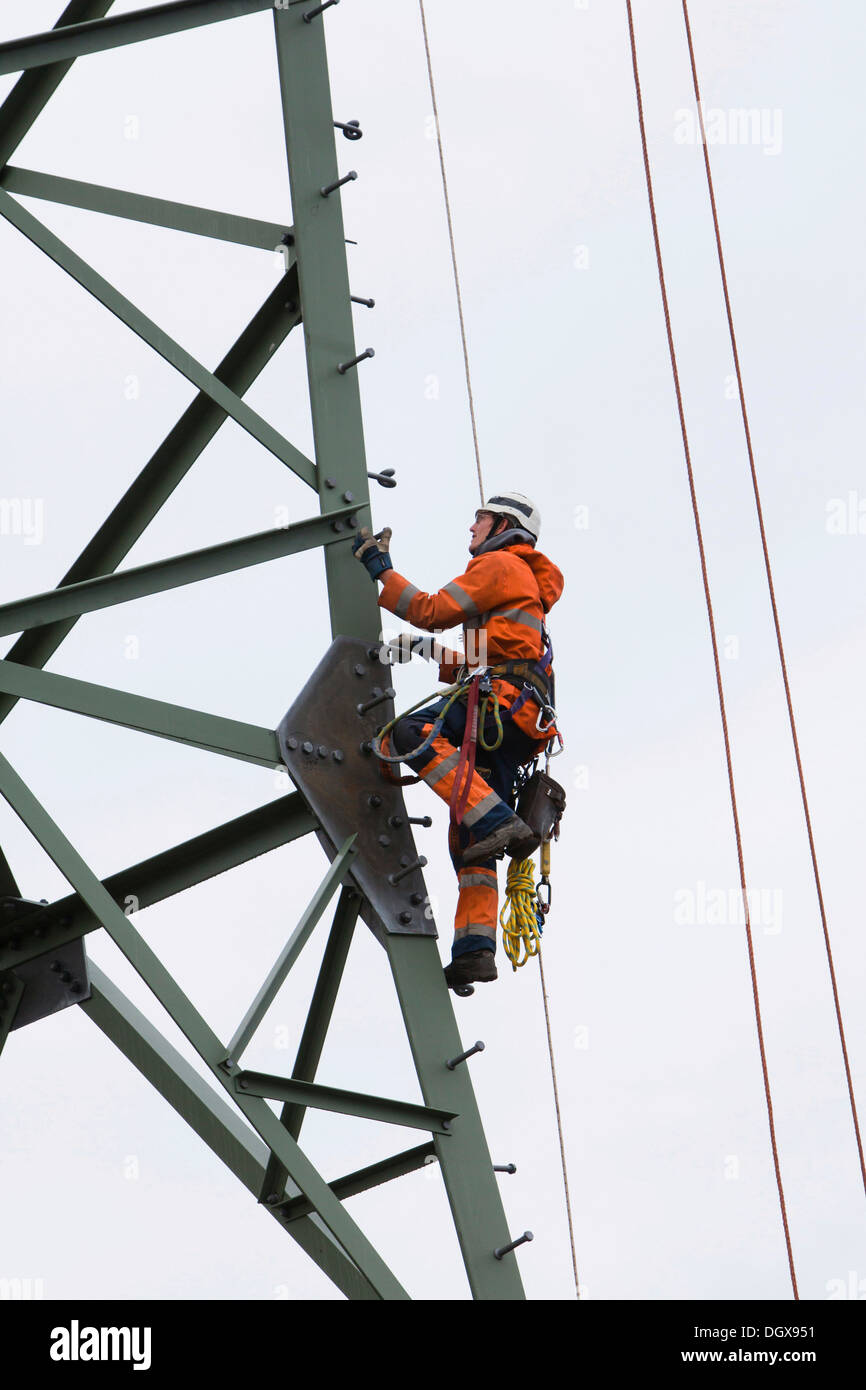 Lineman working with a wire rope hoist on a 380-kV long-distance line ...