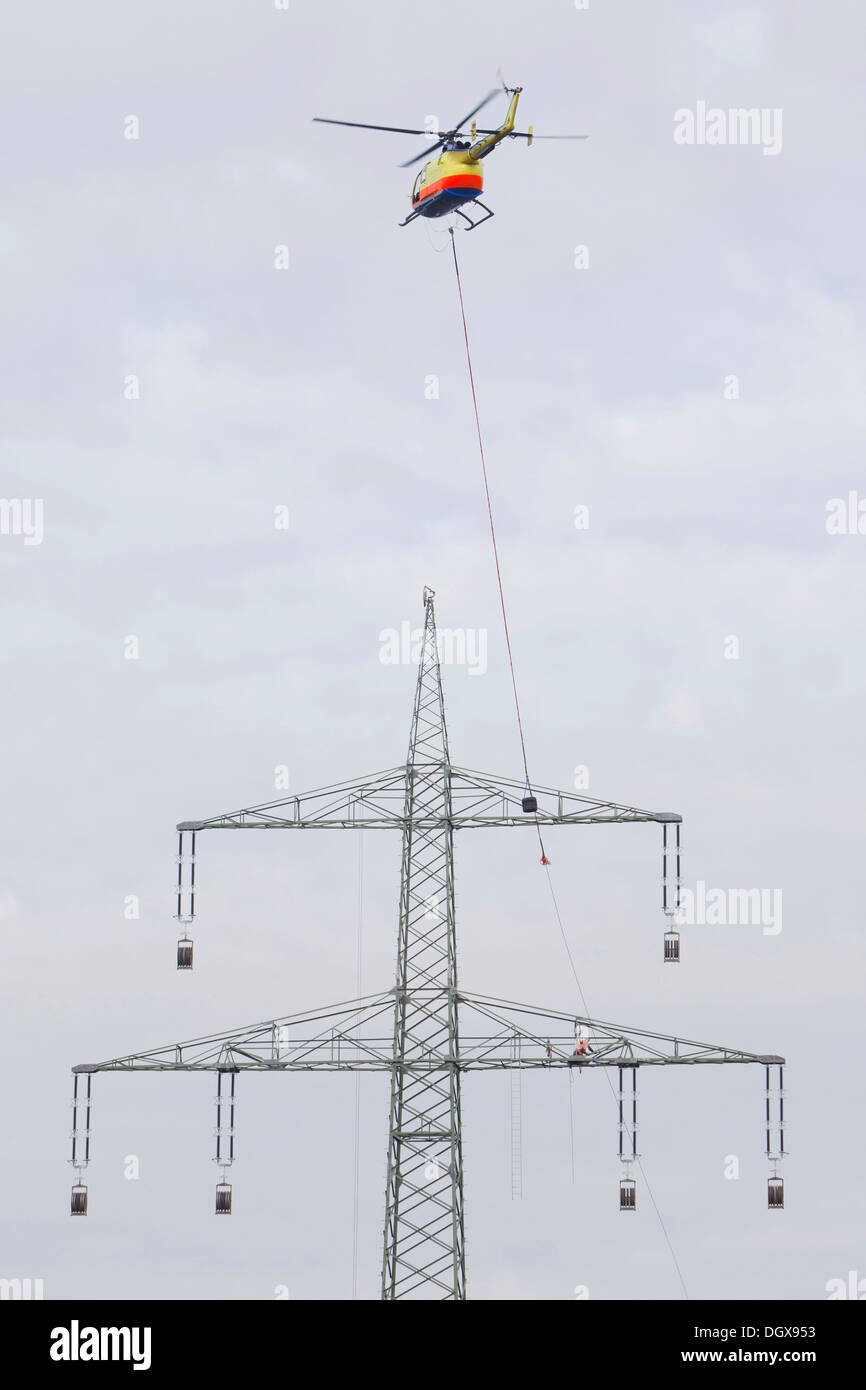 Lineman working with a wire rope hoist on a 380-kV long-distance line ...