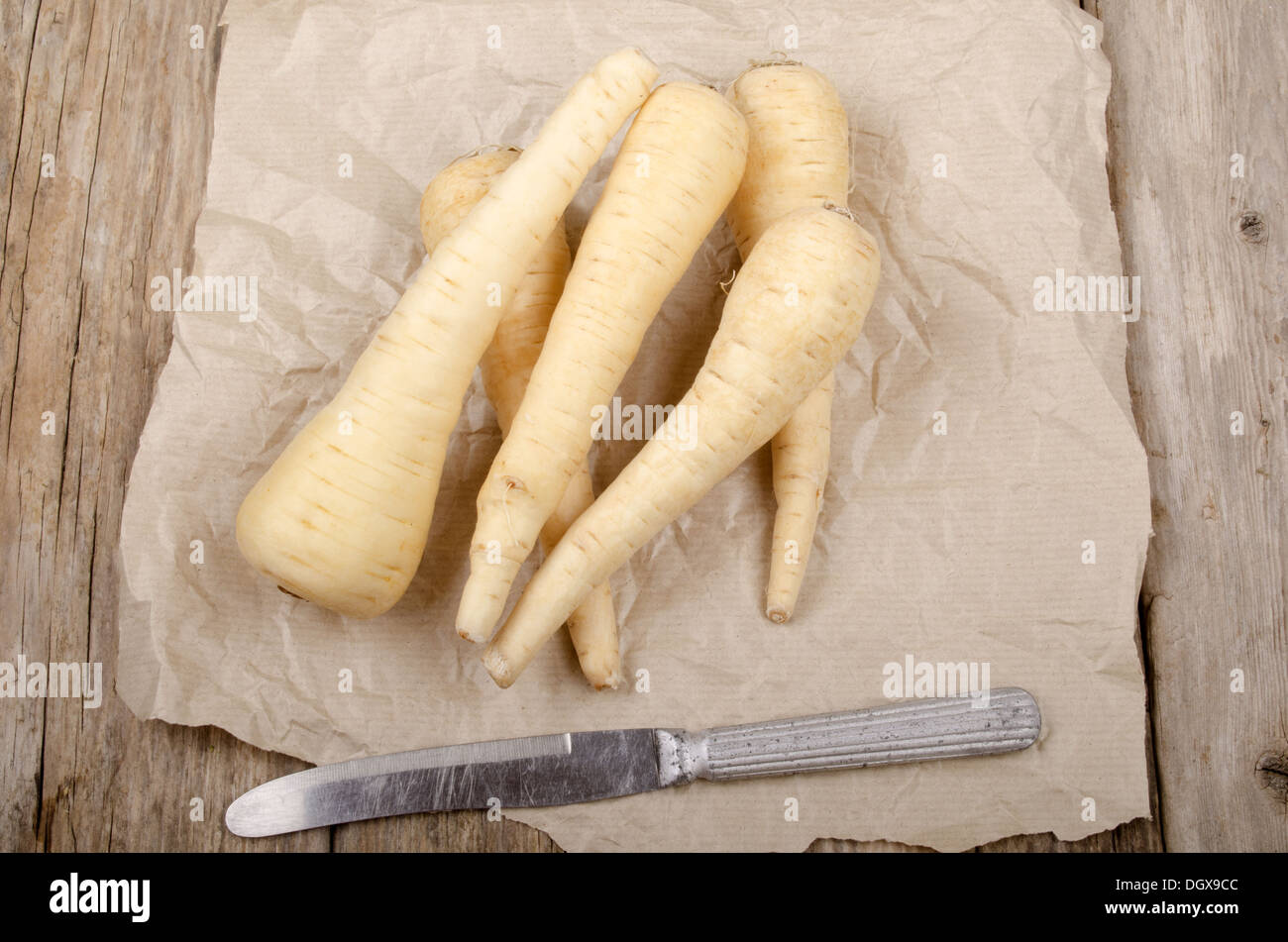 fresh parsnip lie with a knife on brown paper Stock Photo - Alamy