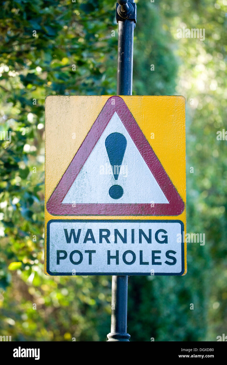A red warning hazard triangle / triangular sign warning pot hole ...