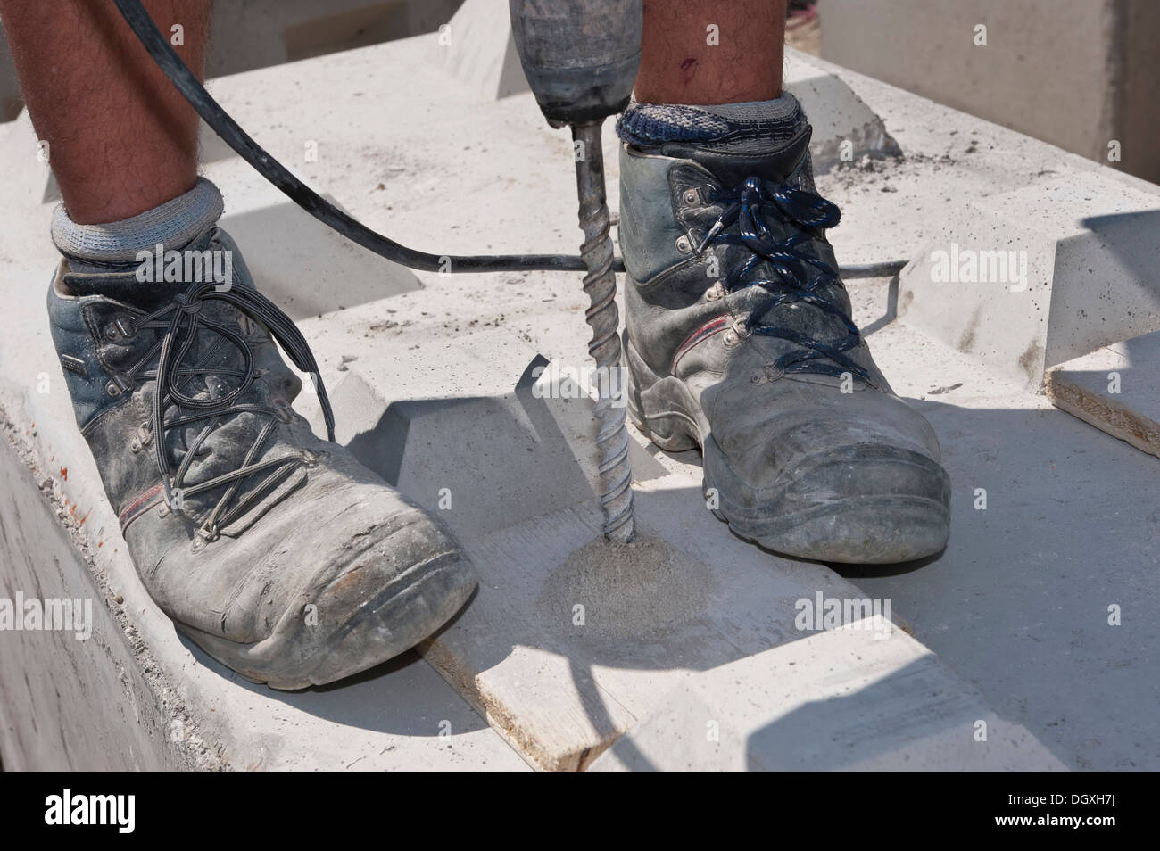 Worker drilling holes into stone blocks that are to be used at a ...