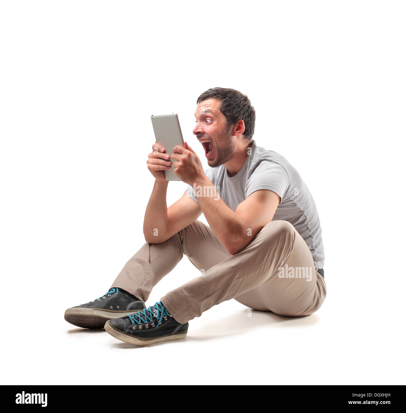 Amazed young man watching a tablet Stock Photo - Alamy